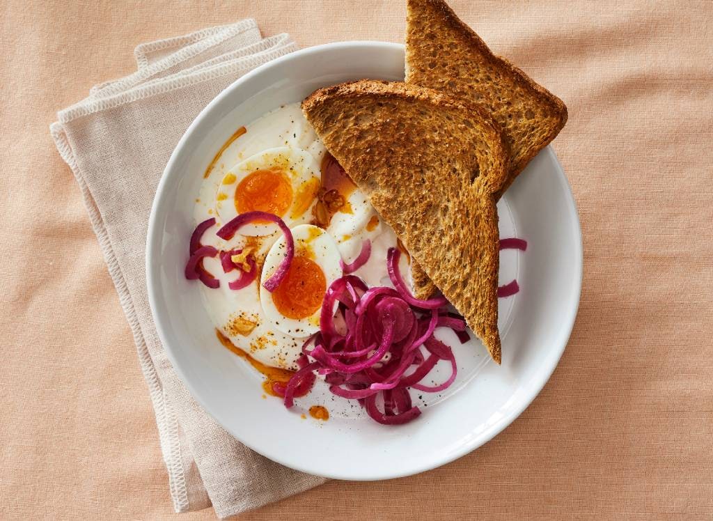 Toast met zachtgekookte eieren, paprika-knoflookolie en ingelegde ui ...